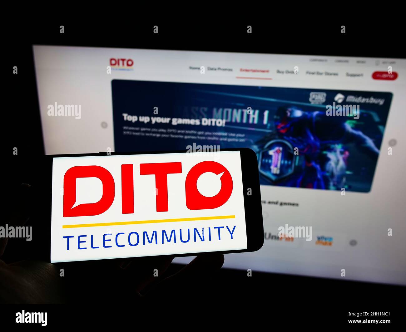 Person holding mobile phone with logo of Philippine company Dito ...