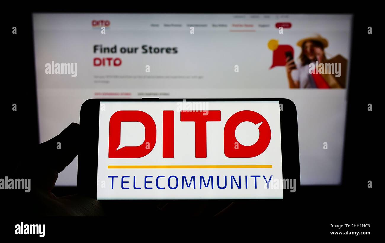Person holding cellpohone with logo of Philippine company Dito ...