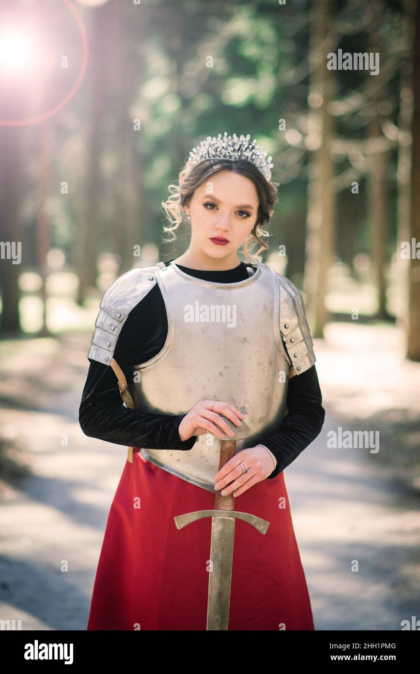 Armed medieval woman warrior in armor posing while standing on ...