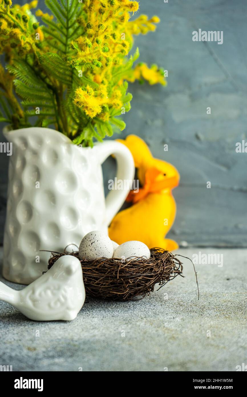 Festive table setting for Easter holiday with mimosa flowers and nest ...
