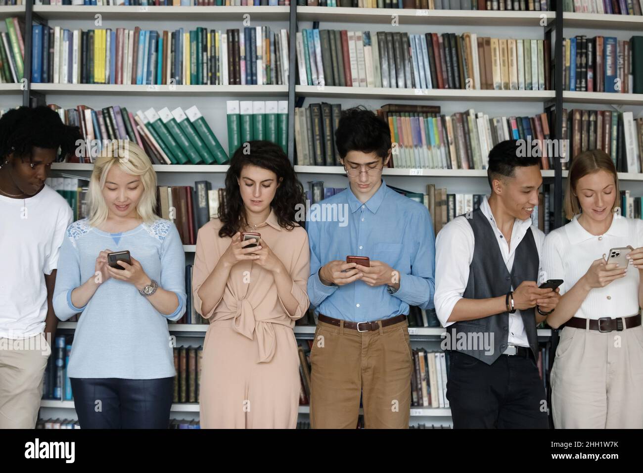 Multiethnic group of freshman students engaged in cellphone using Stock ...