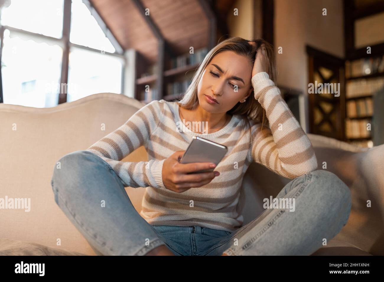 Worried confused lady using mobile phone, looking at screen Stock Photo ...