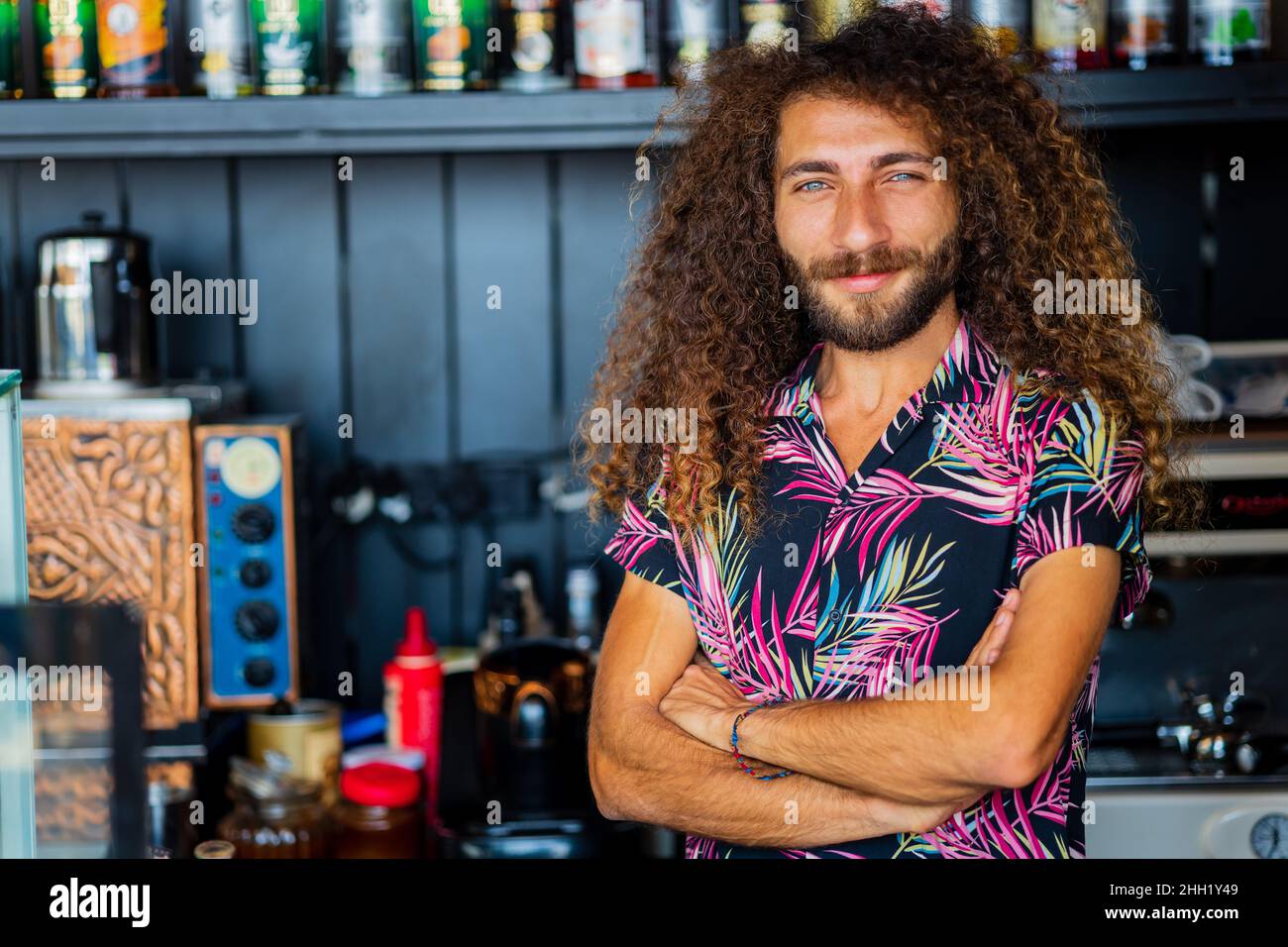long curly haired mixed race man barman making beverage alcoholic drink ...