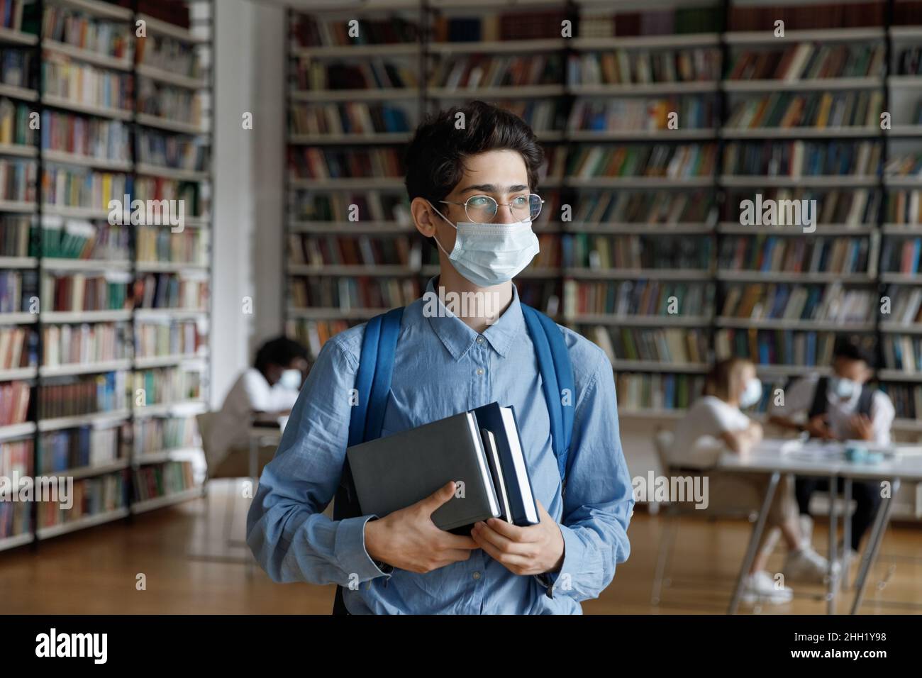 Thoughtful fresh student wearing facial medical mask protecting breath ...