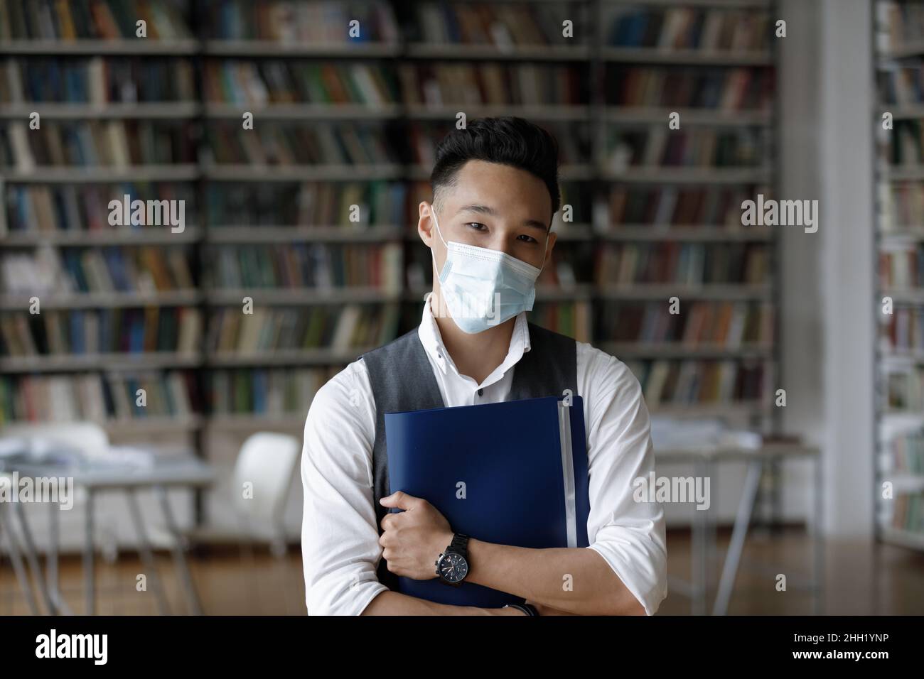 Young Asian student wearing face mask, posing in university library ...