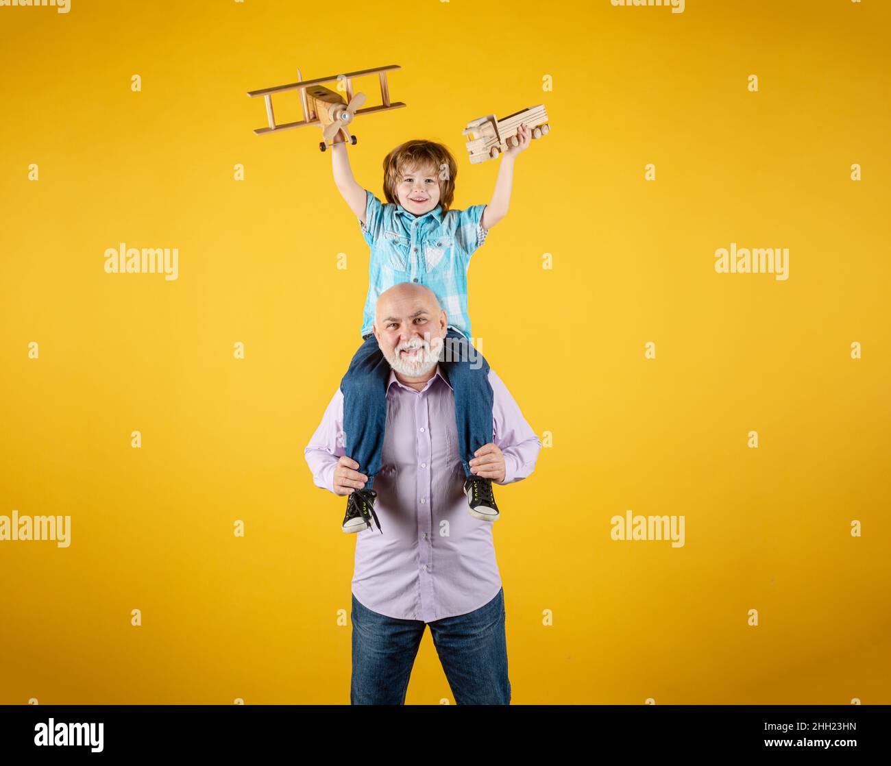 Child boy and grandfather with toy plane and wooden toy truck. Men ...