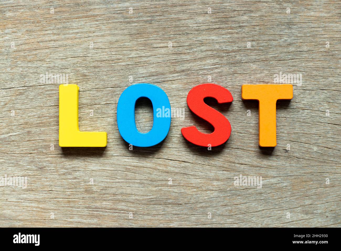 Color alphabet letter in word lost on wood background Stock Photo - Alamy