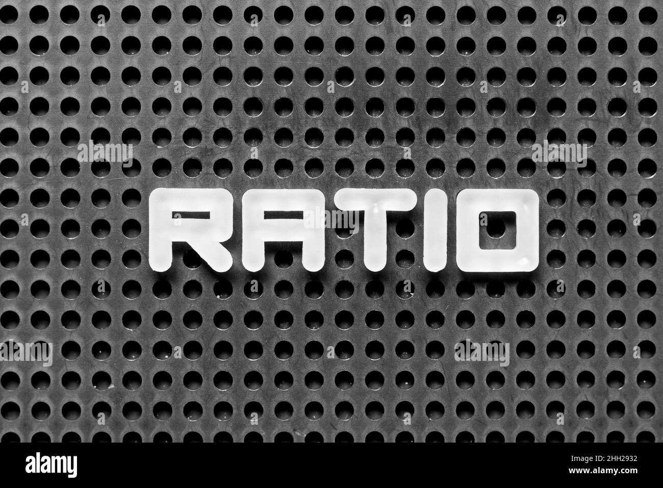 White alphabet letter in word ratio on black pegboard background Stock ...