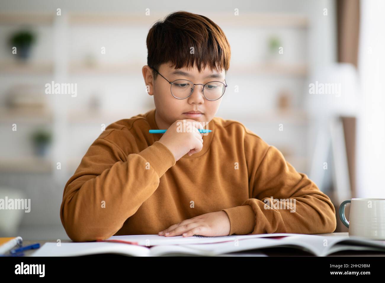 Smart korean teen kid doing homework at home Stock Photo - Alamy
