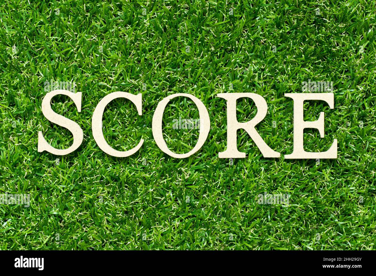Wood letter in word score on green grass background Stock Photo - Alamy