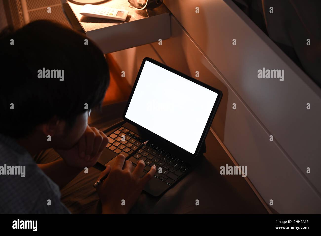 Man browsing internet with computer table at night in bedroom Stock ...