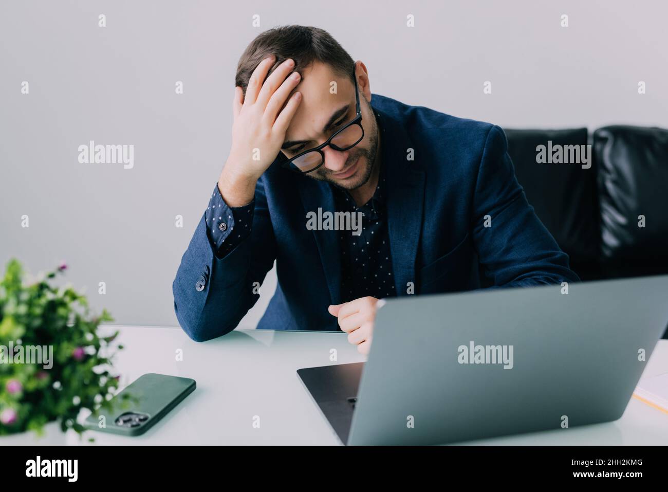 Portrait of upset businessman at desk in office. Businessman being ...
