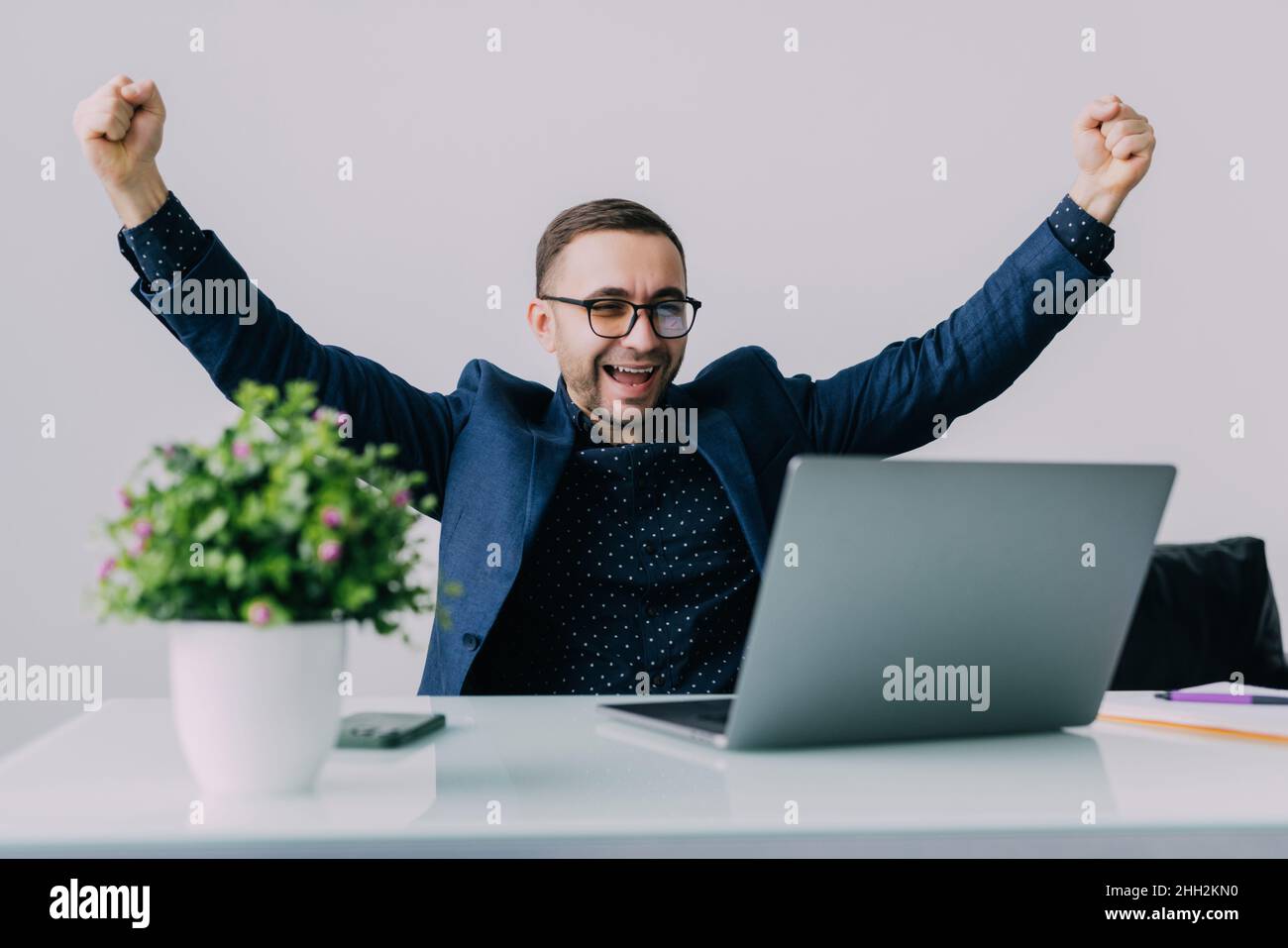 Happy successful business man cheering with clenched fists in office ...