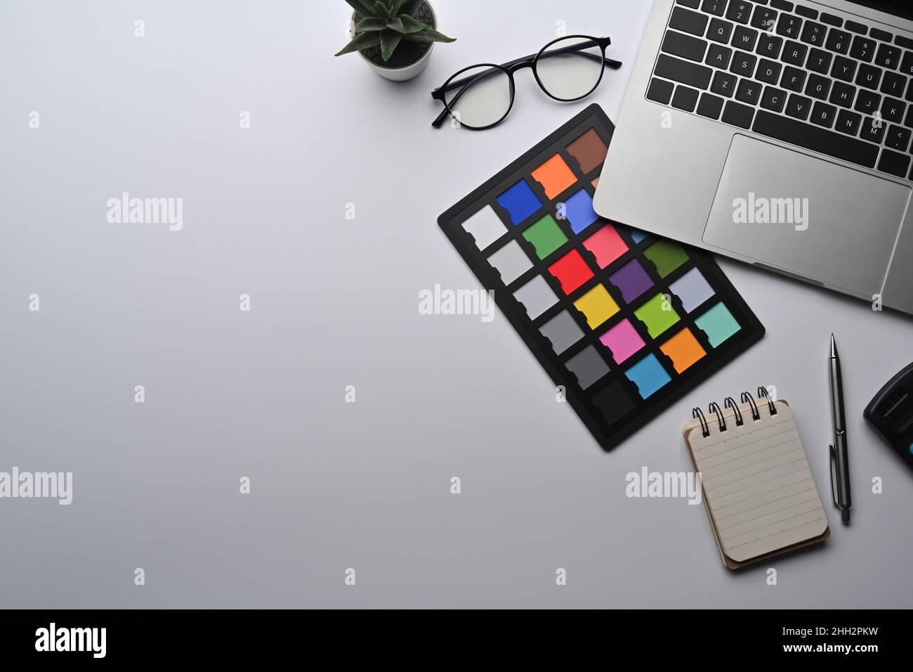 Creative designer workspace with laptop computer, notebook, glasses and ...
