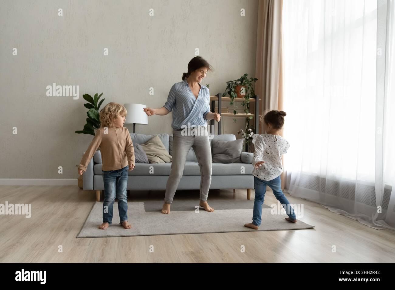 Happy young single mother dancing with cute kids Stock Photo - Alamy