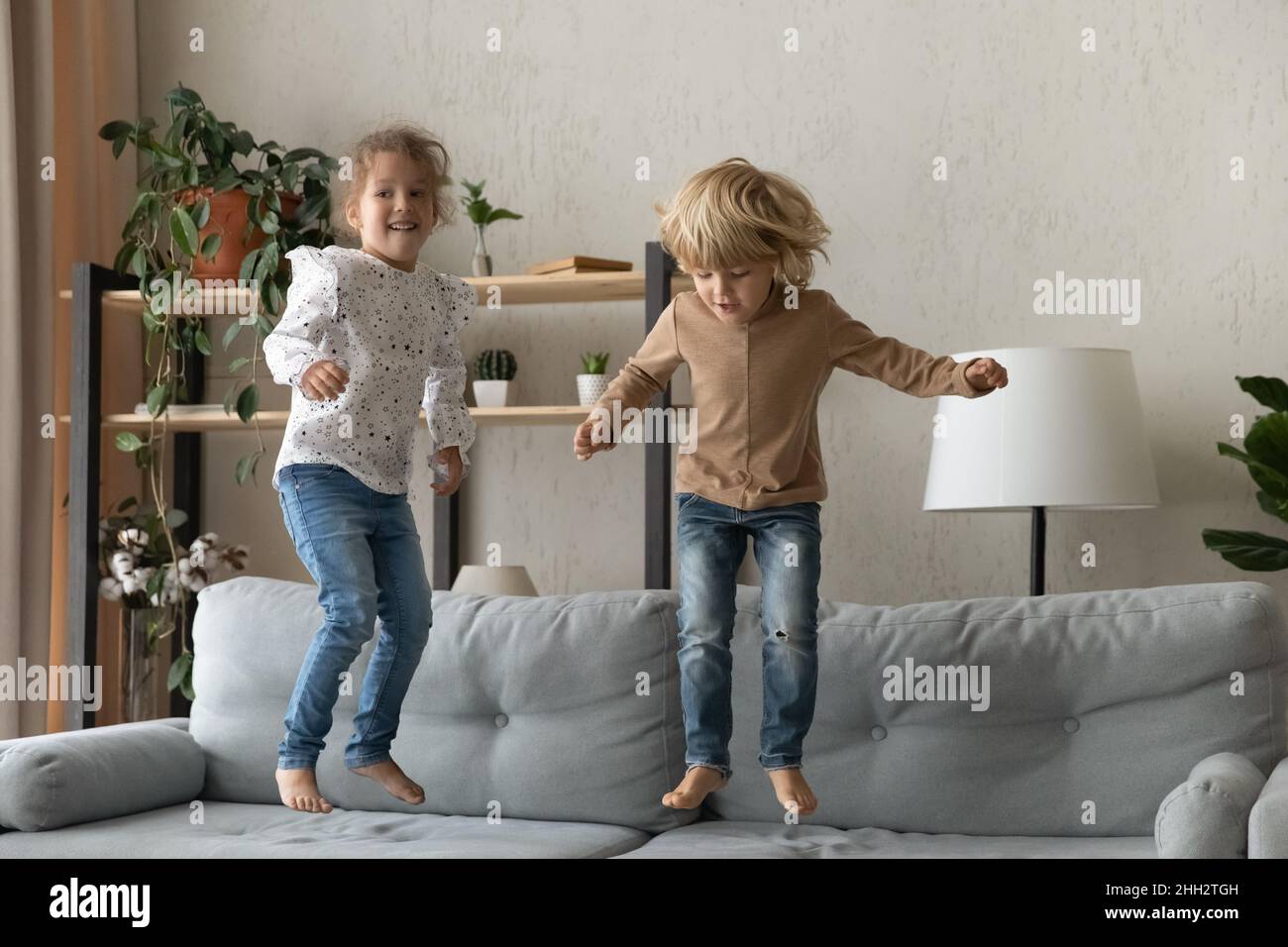 Happy laughing small children jumping on sofa Stock Photo - Alamy