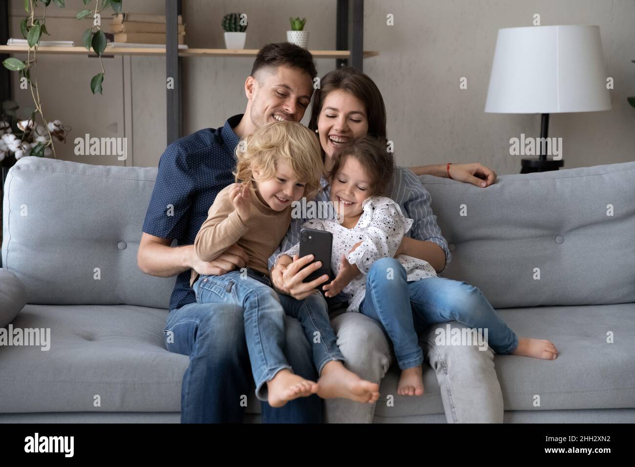 Happy bonding two generations family using cellphone at home Stock ...