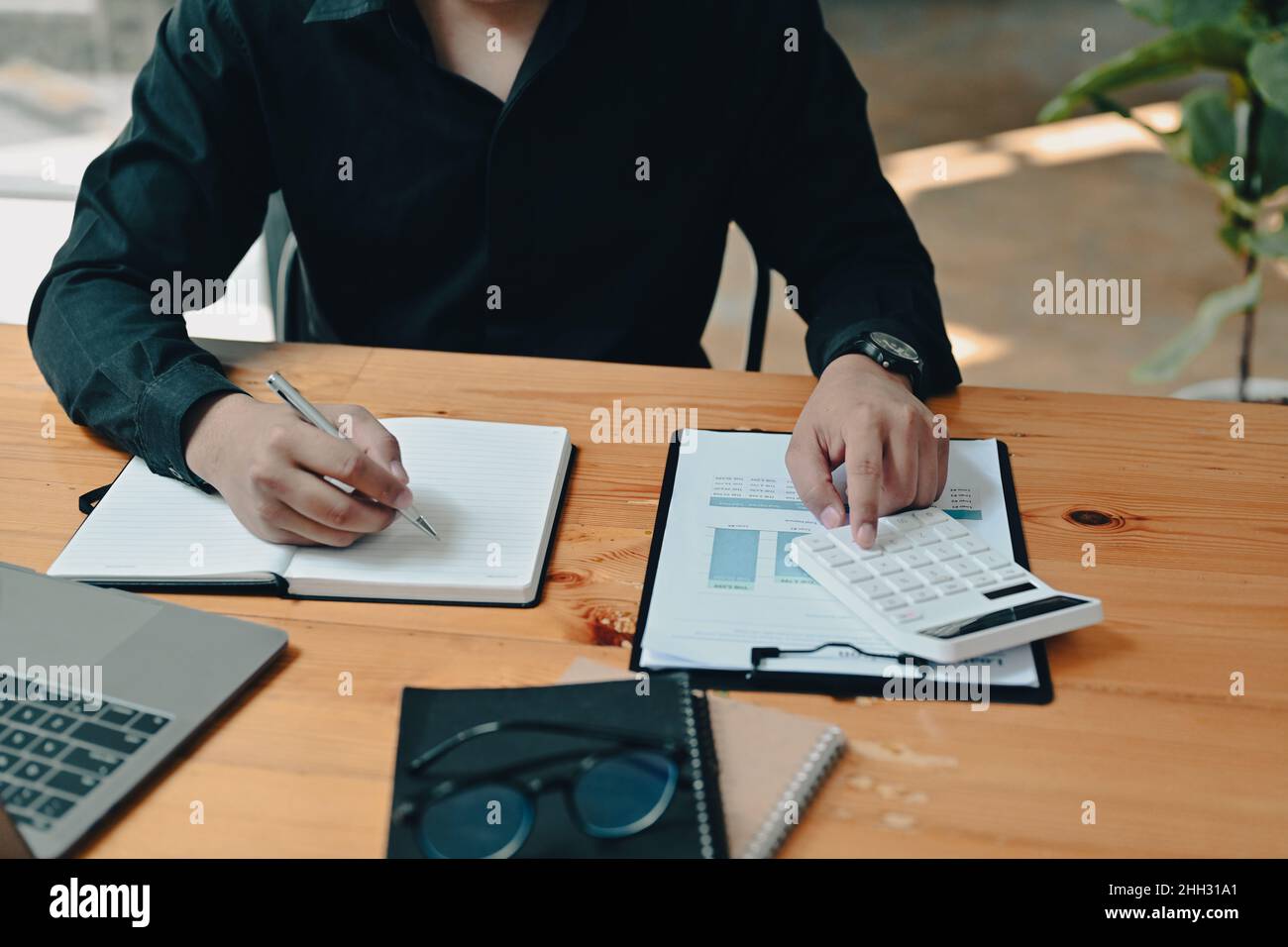Male accountant using calculator and working with laptop at office ...