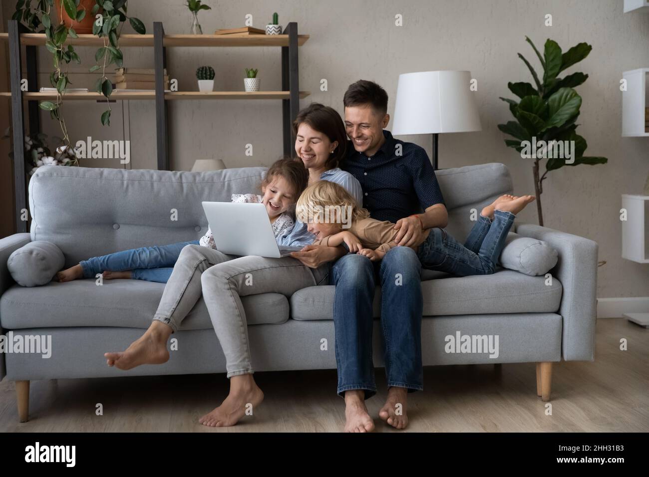 Happy young parents and small kids using computer Stock Photo - Alamy