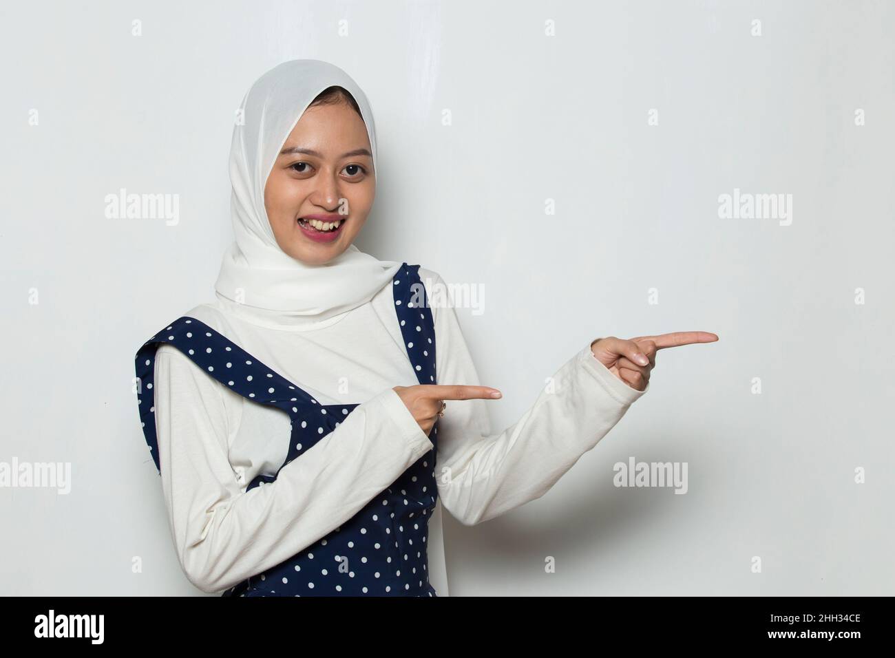 asian muslim woman pointing with fingers to different directions. Copy ...