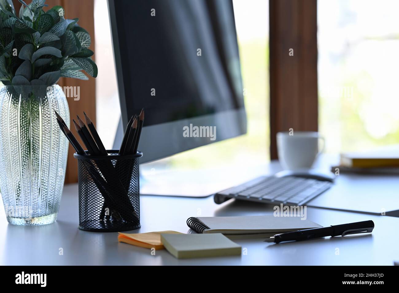 Computer, pencil holder and sticky notes on white office desk Stock ...