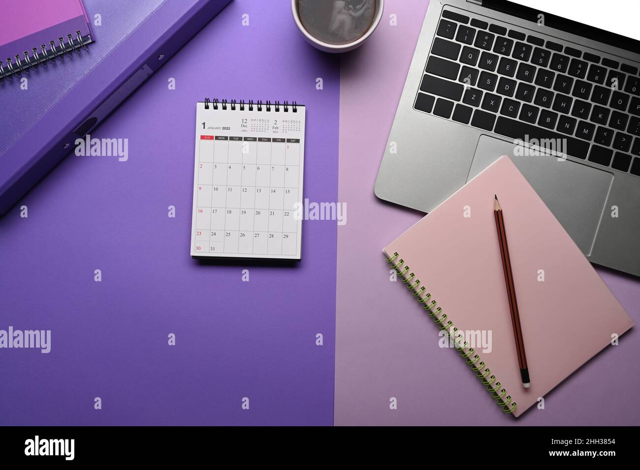 Top view calendar, notebook ad laptop computer on purple background ...