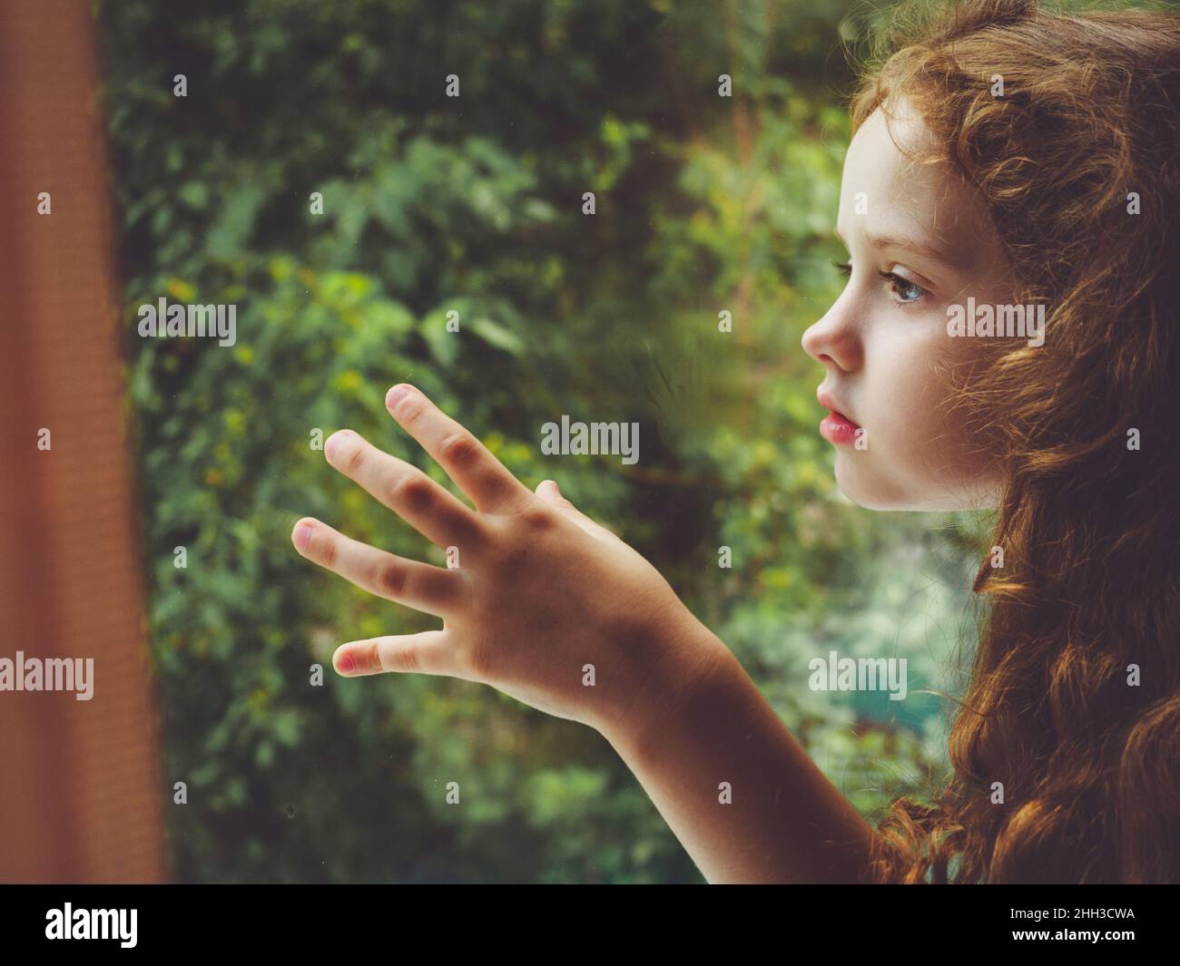 Sad child looking out the window Stock Photo - Alamy