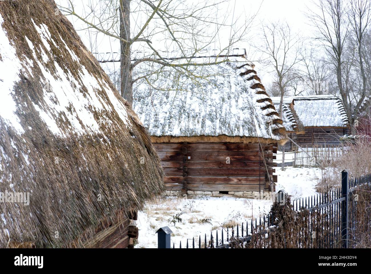 historic thatched timber cottages in skansen in Lublin - winter ...