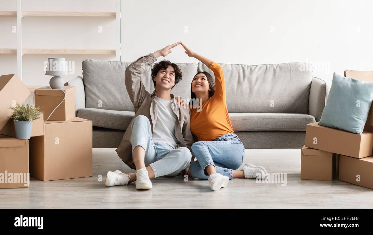 Cheery millennial Asian couple relocating to new home, making house ...