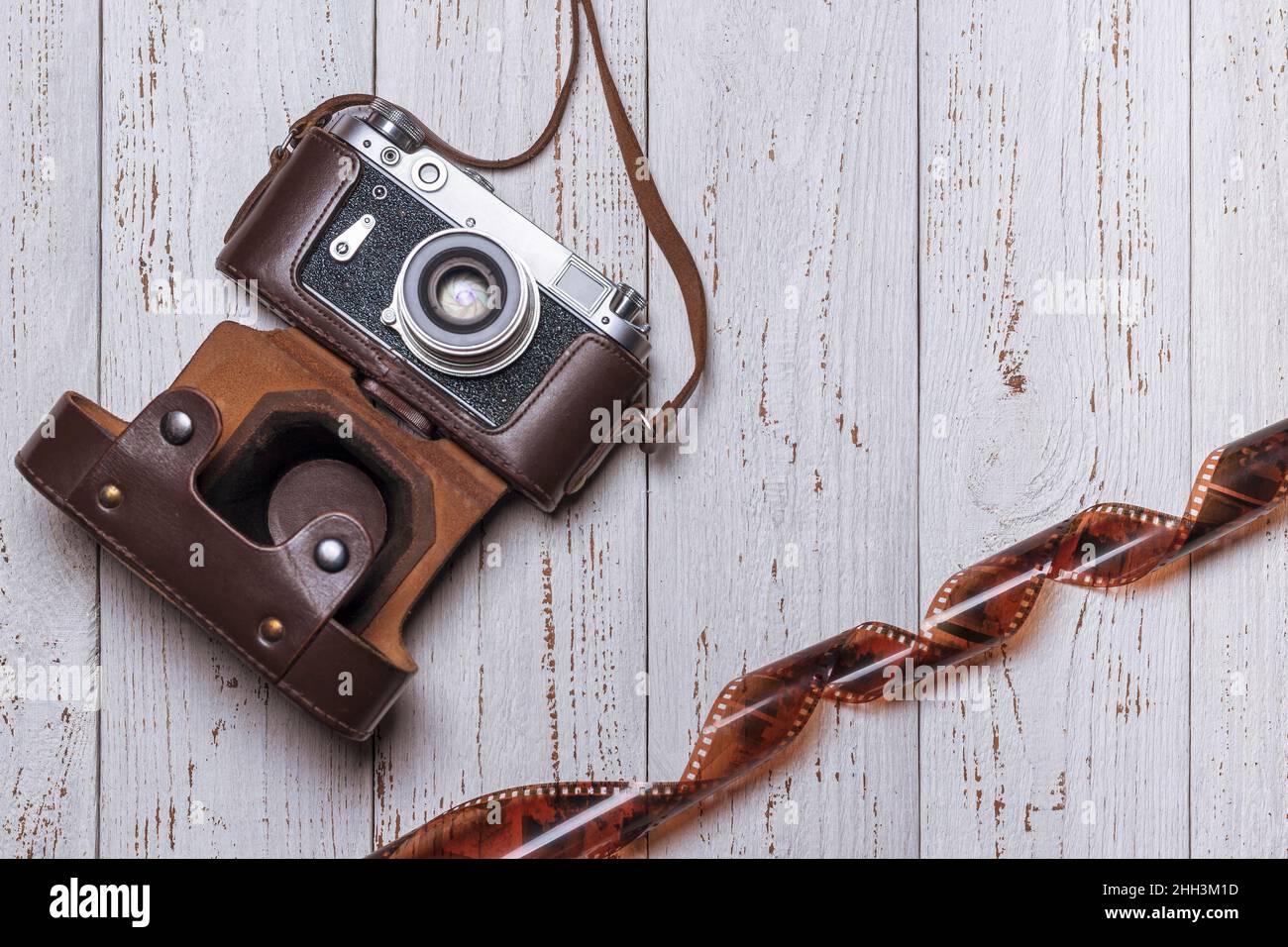 An old retro camera in a brown leather case with film. Background from ...
