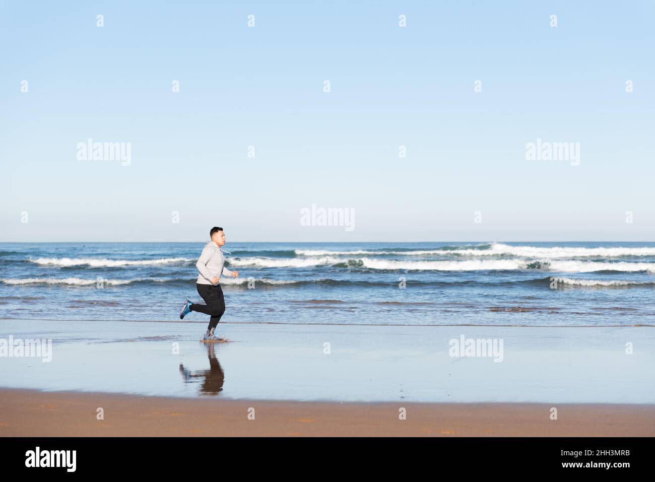 Latin sportive man running at seaside focused on his goals. Sport ...