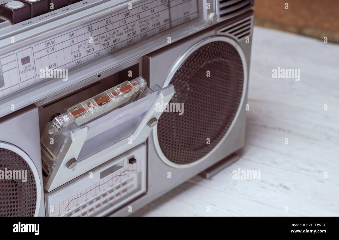 An audio cassette in an old retro tape recorder that is on the table ...