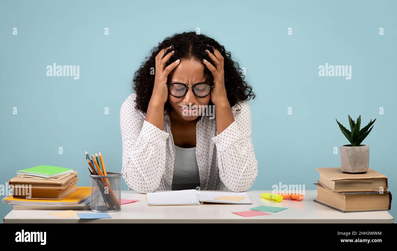 Tired African American female student crying over books and notebooks ...