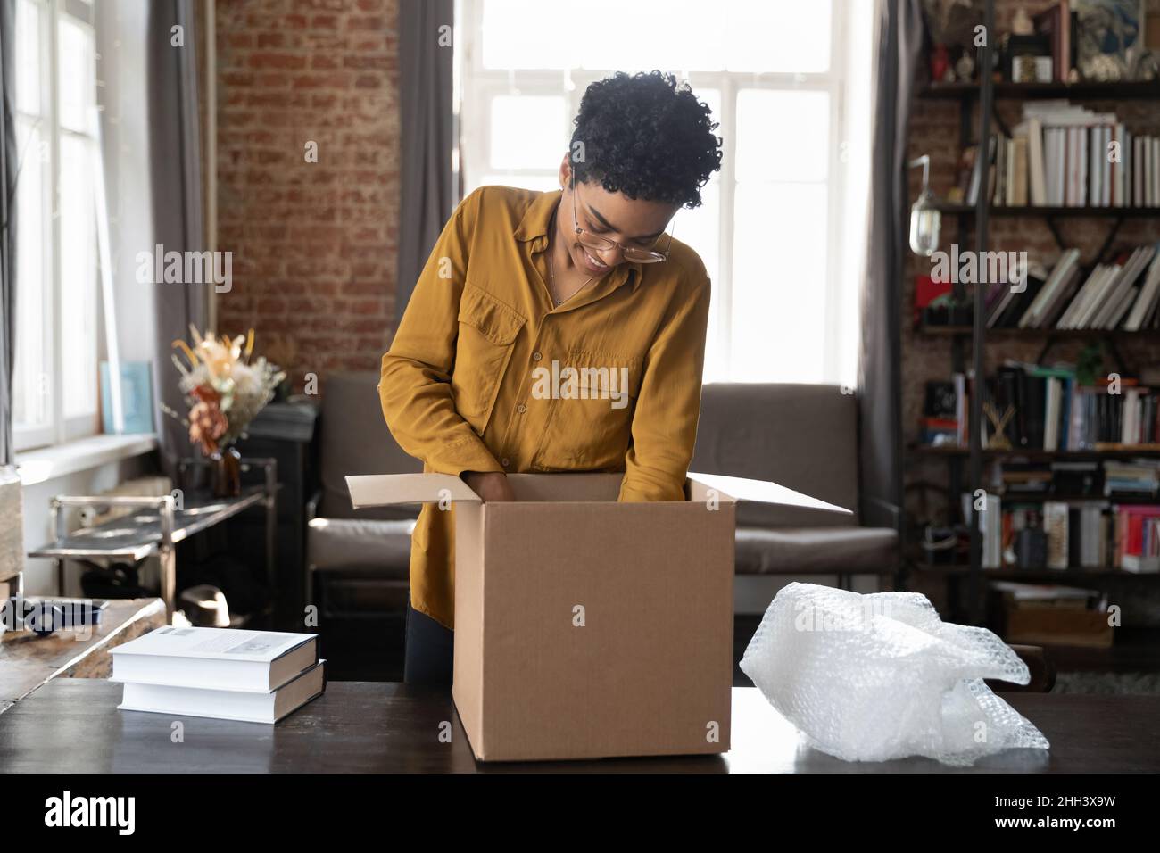 Happy excited Afro American customer, student girl unpacking received ...