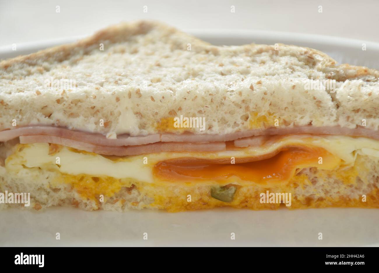 close up of sandwich stuffed ham and fried egg on white background ...