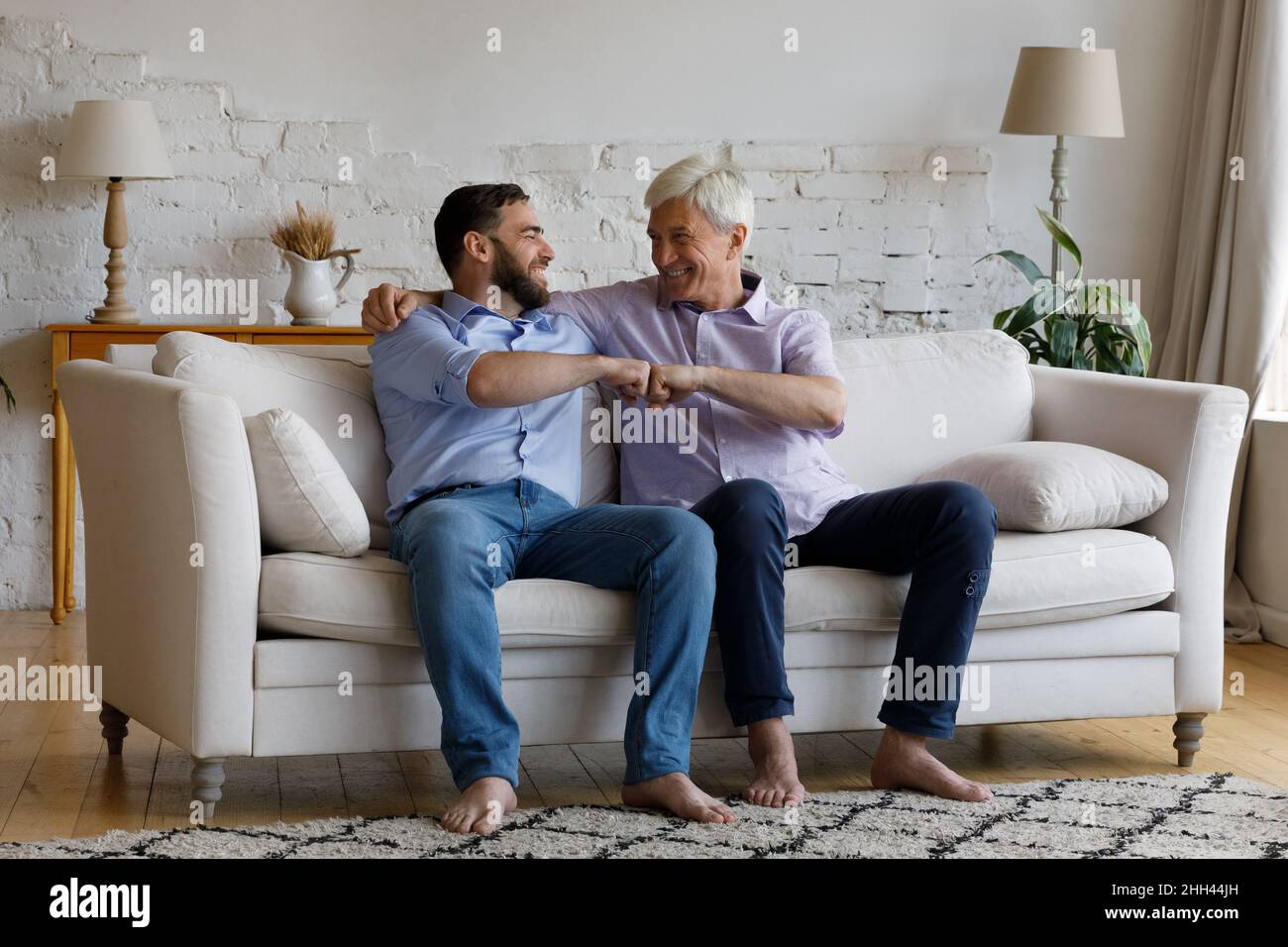 Happy mature grey haired dad congratulating adult son on success Stock ...