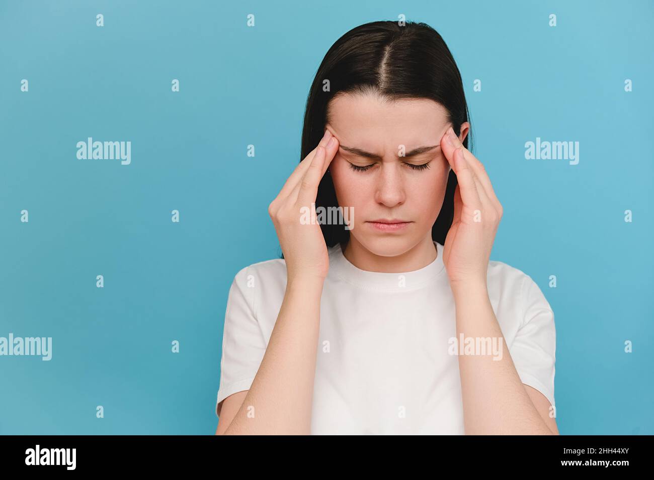 Close up of tired sad young caucasian woman suffering from headache ...