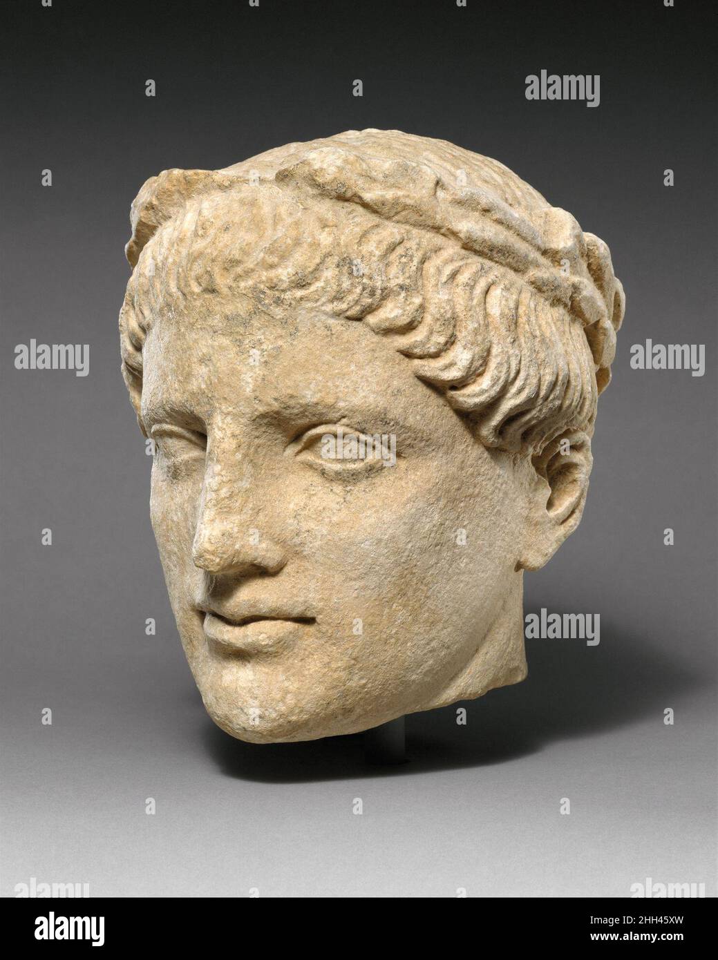 Limestone head of beardless male votary with wreath of leaves mid–3rd ...