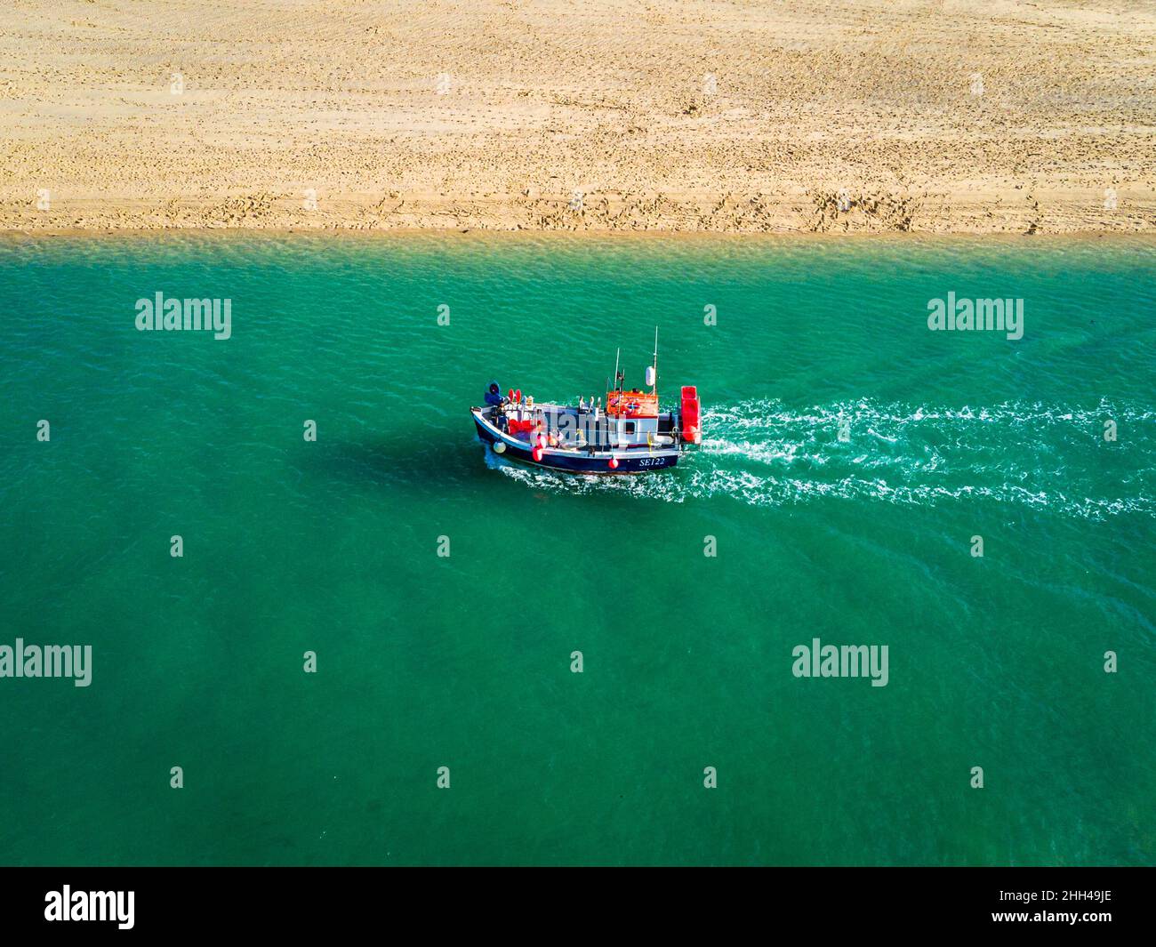Fishing boat heading out to sea Stock Photo - Alamy