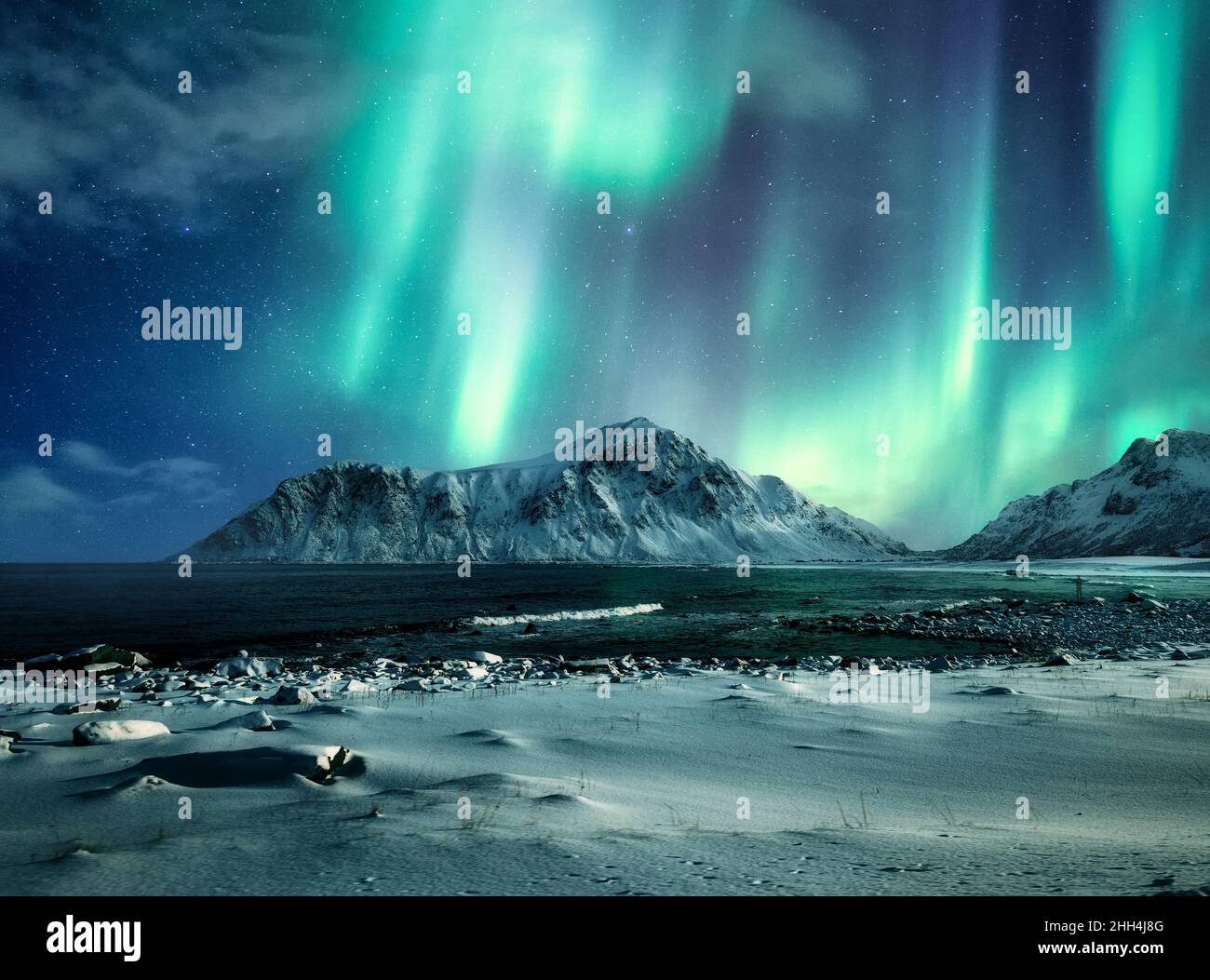 Aurora borealis, Northern lights over snow mountain range on coastline ...
