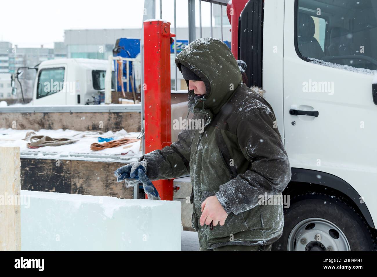 Worker at the construction site of the ice town at the truck crane ...