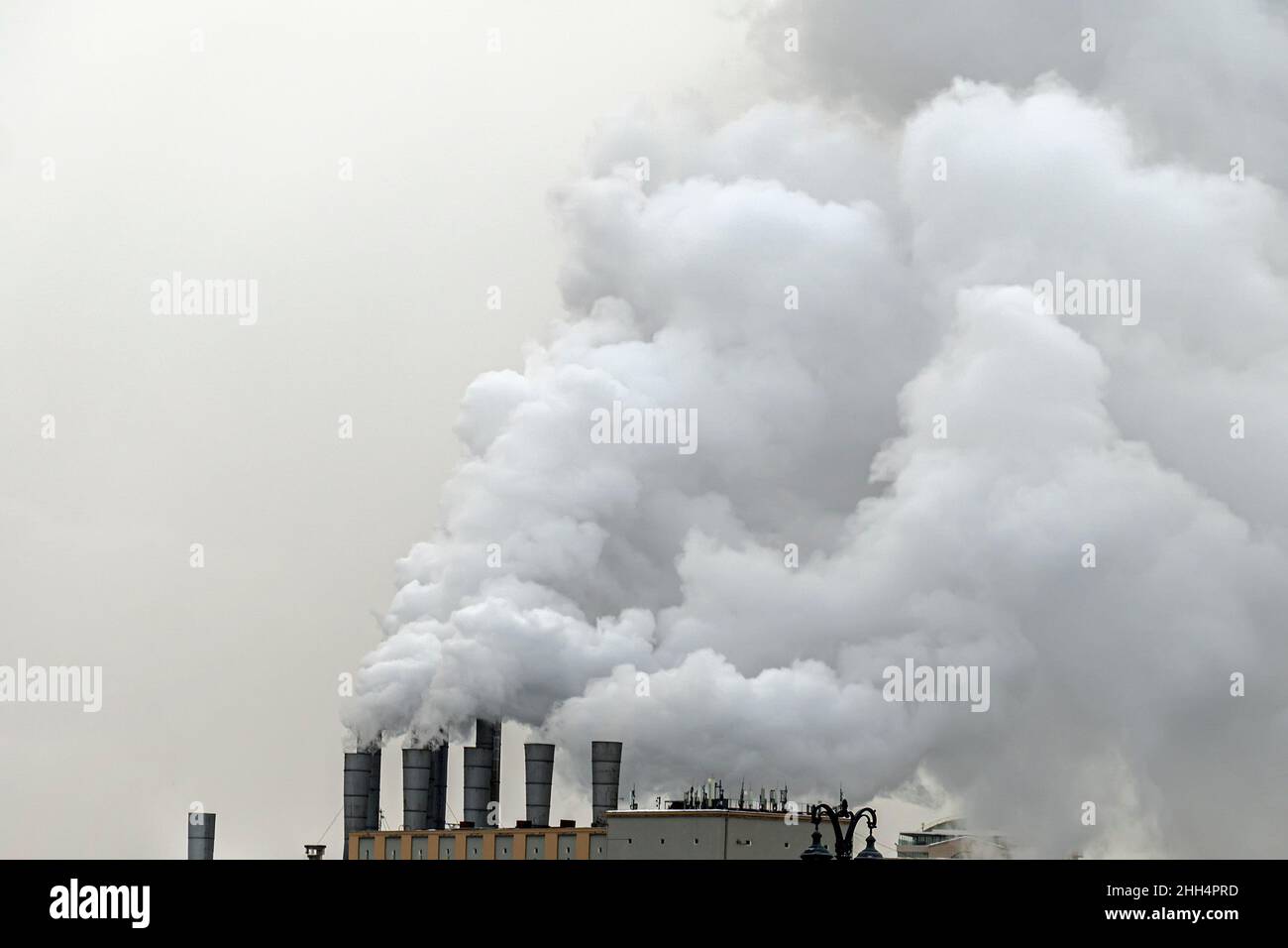Smoke from chimneys of heating plant. Air pollution. Factory pipes with ...
