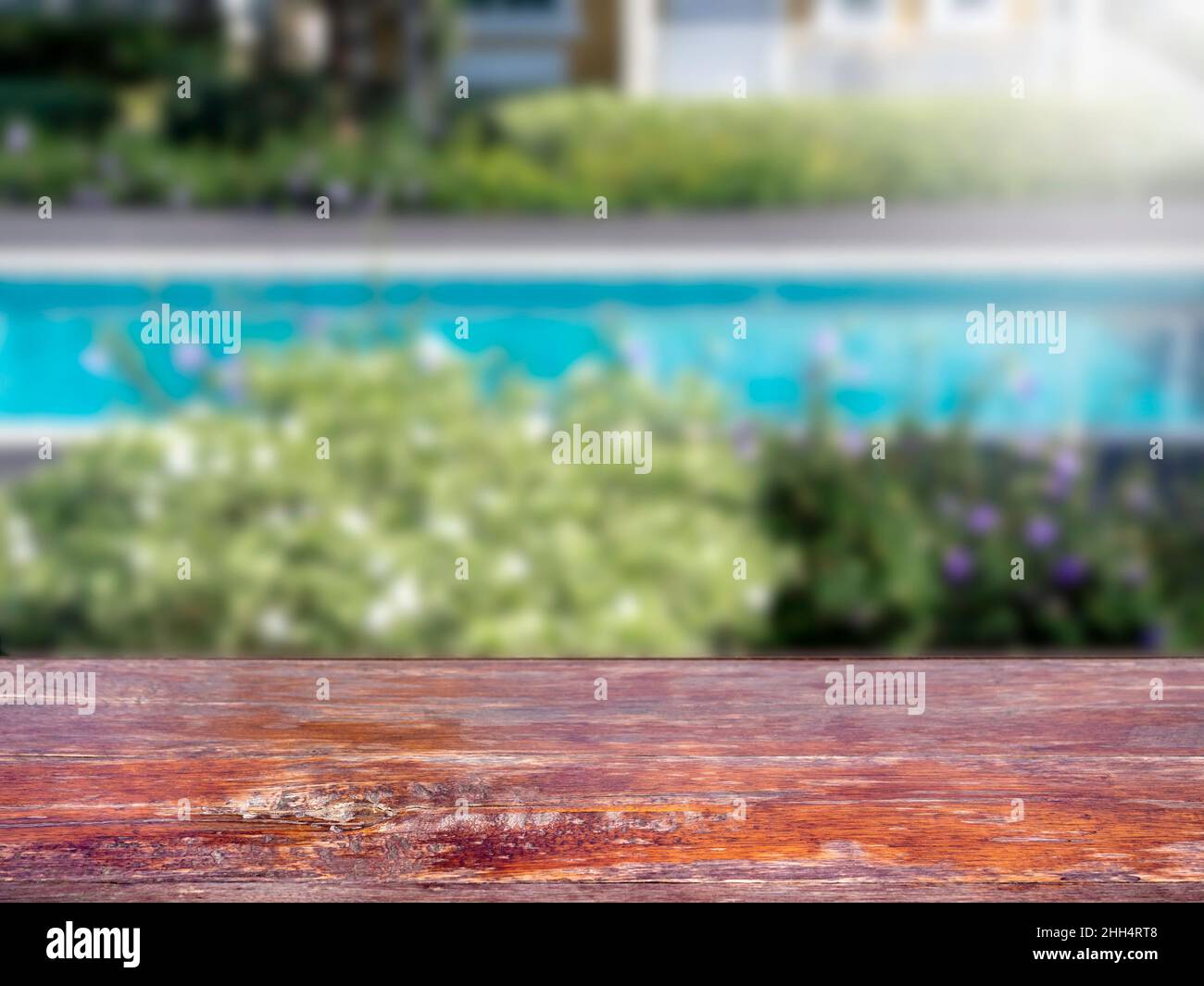 Close up empty grunge wooden top table in front of a swimming pool on ...