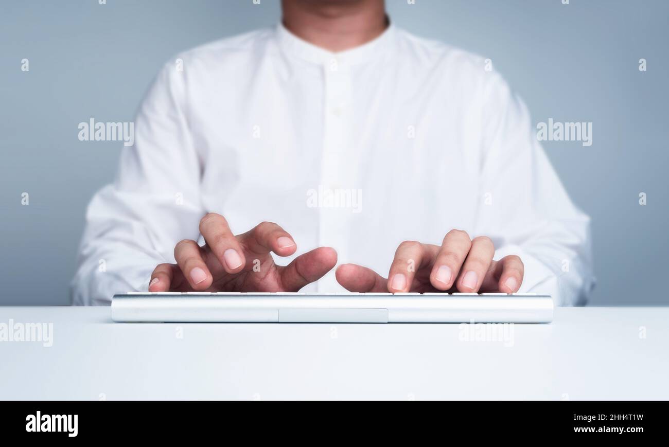 Businessman's hands in white shirt typing on modern keyboard computer ...