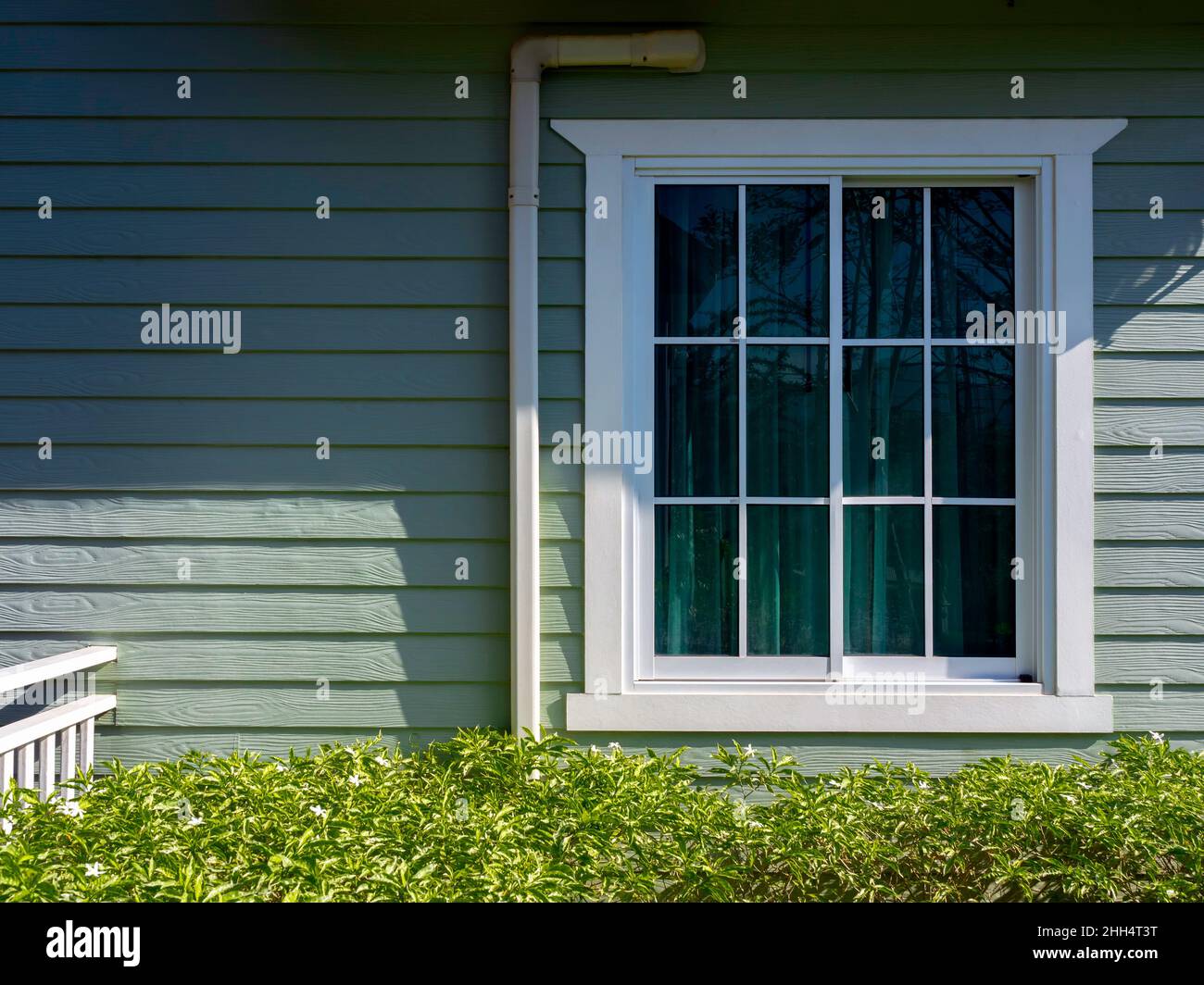 A white house window with glass, green curtain decoration on the small ...