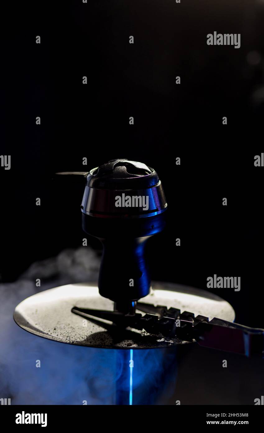 Shisha bowl with craft tobacco and coil with hookah smoke background ...