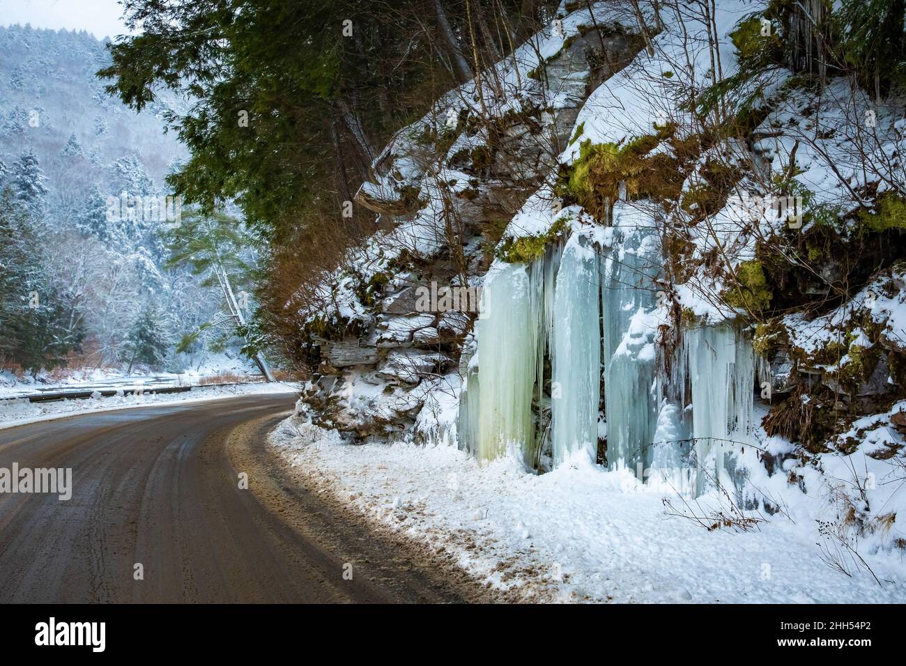 Icy road pavement with frozen ice along the side dangerous conditions ...