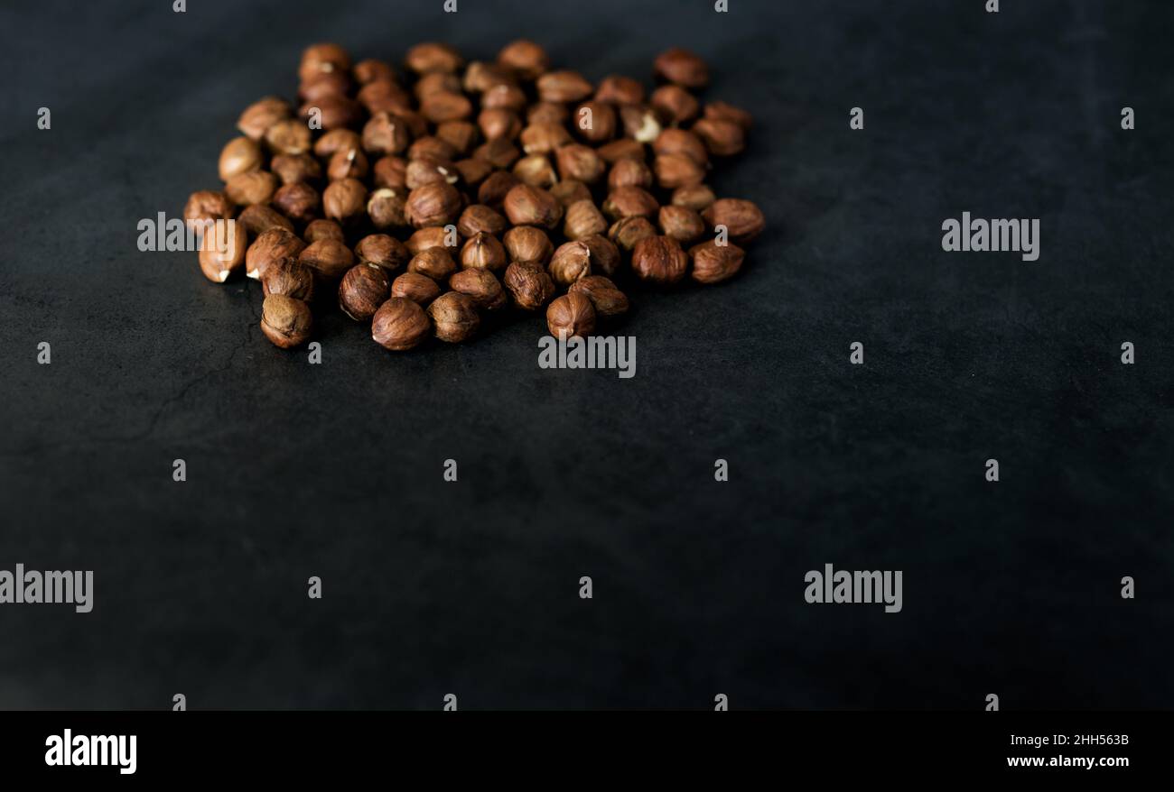Many hazelnuts on dark backdrop. heap or stack of hazelnuts. Hazelnut ...
