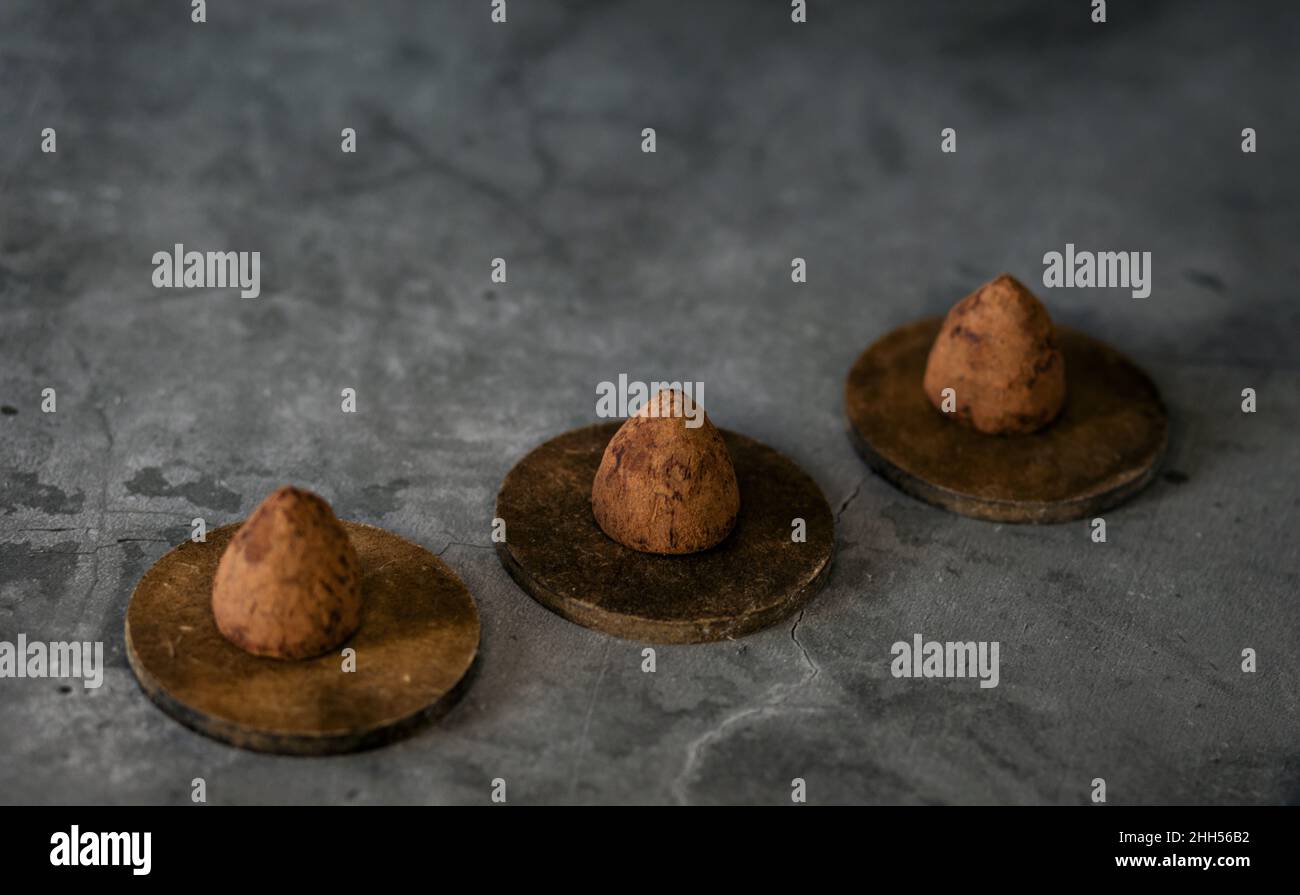 Three chocolate truffles on cocoa powder on dark background Stock Photo ...