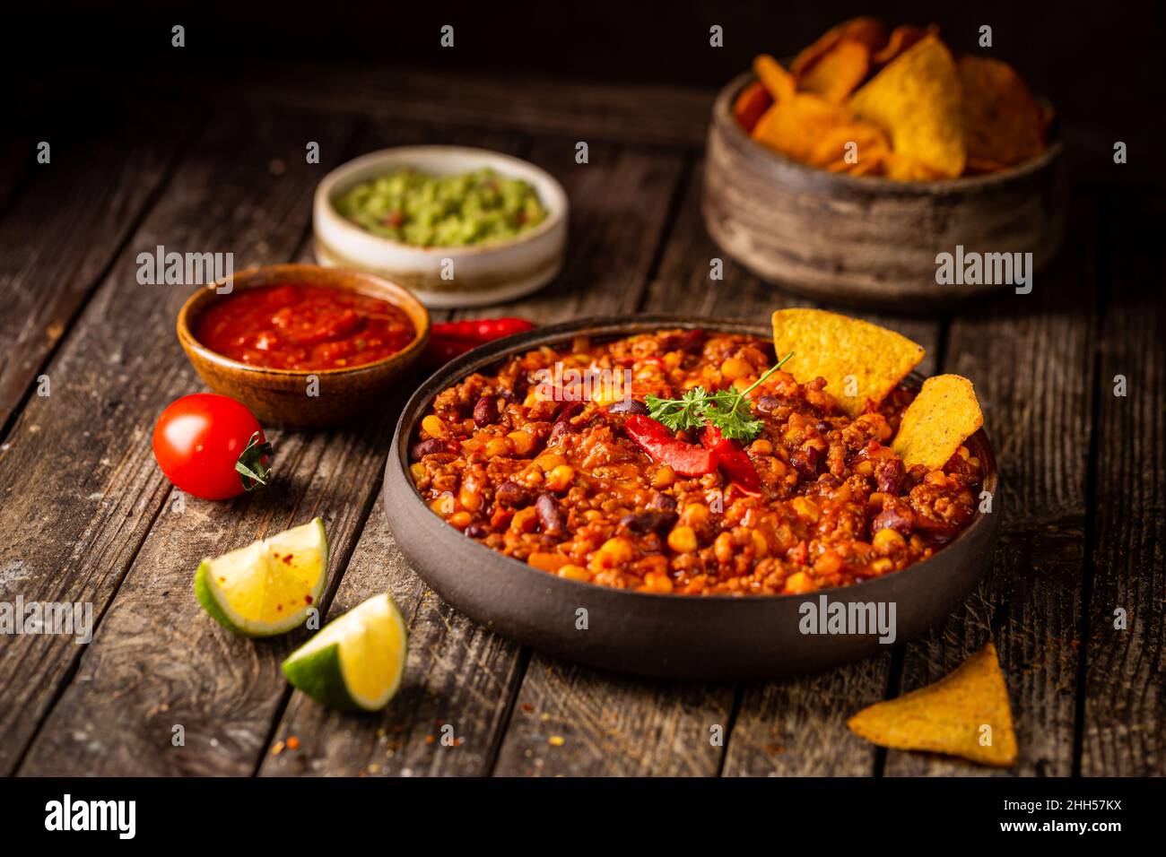 Mexican hot chili con carne in a bowl with tortilla chips on wooden ...